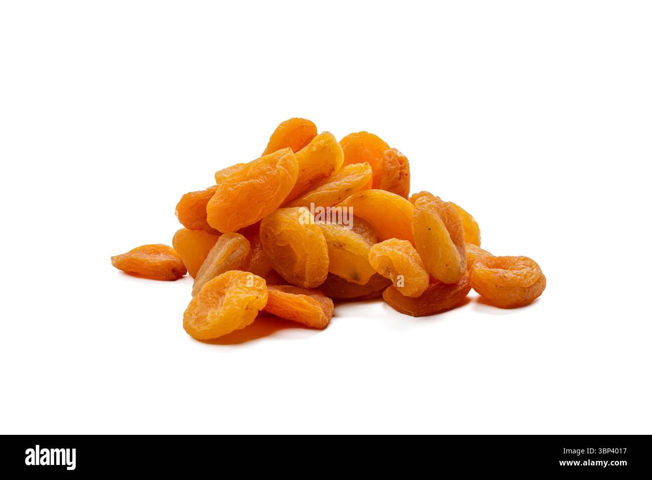 A heap of dried apricots displayed on a white background. Their bright ...