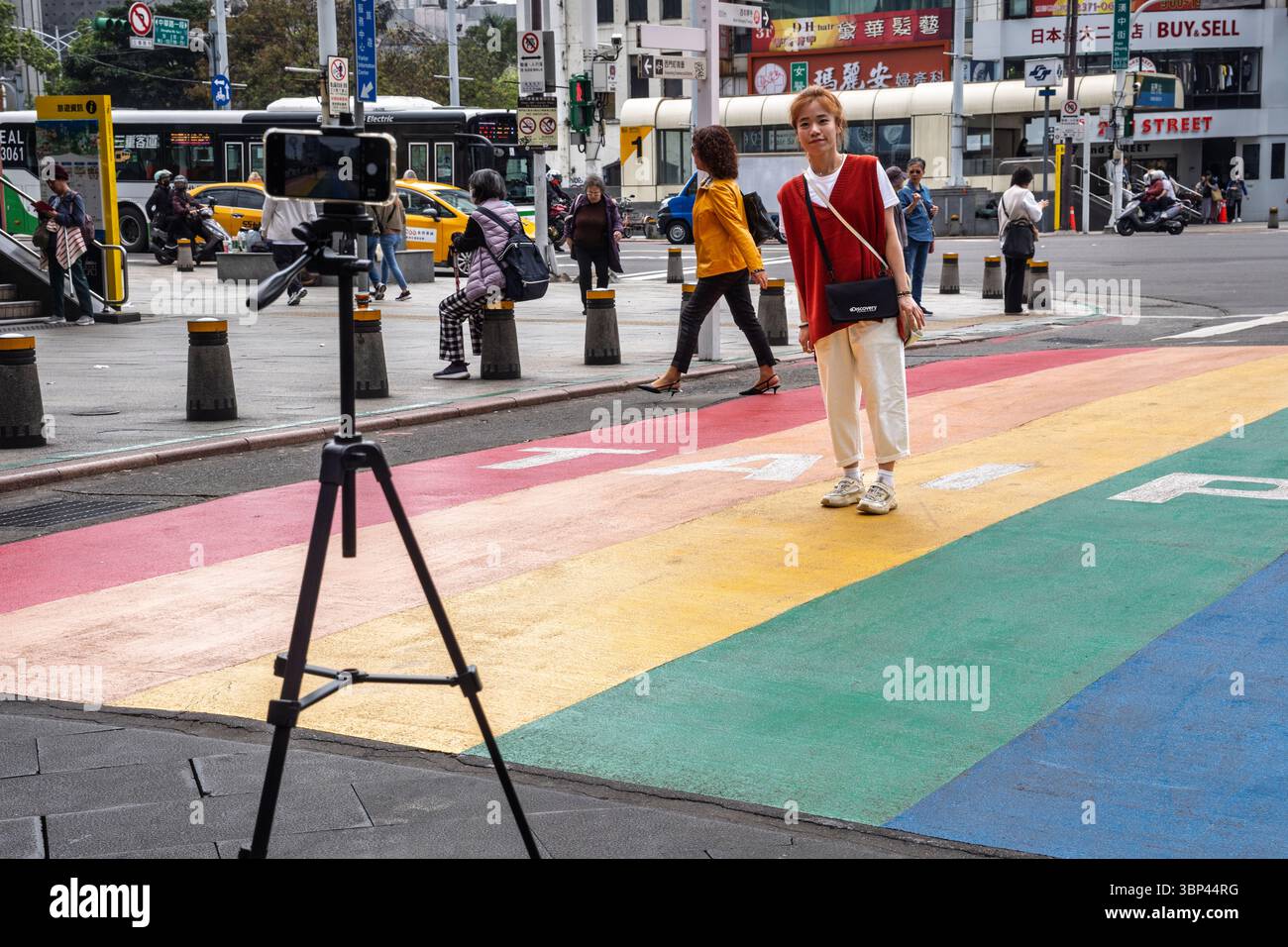 A young woman poses for a selfie at Rainbow Six, the famous rainbow crosswalk in the Ximending ...