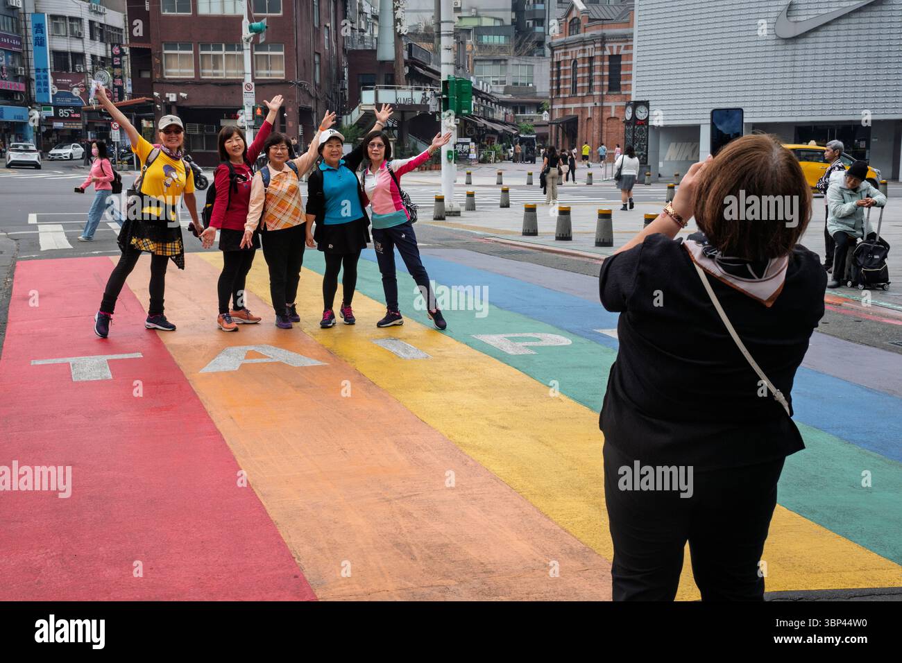 A group of middle aged women posing for a photo at Rainbow Six, the famous rainbow crosswalk in ...