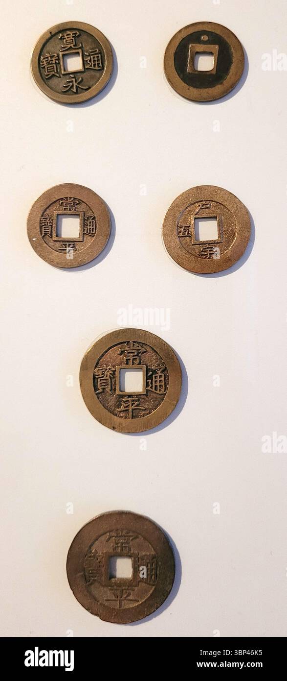 A top-down photograph of a collection of six circular gilt bronze cash ...