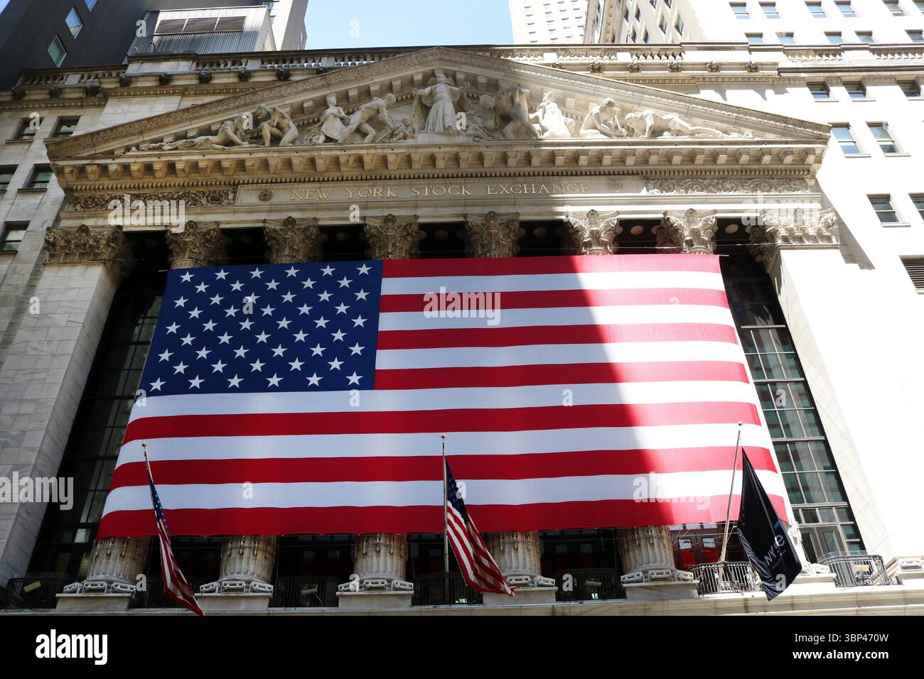 A photograph of the New York Stock Exchange with the American flag ...
