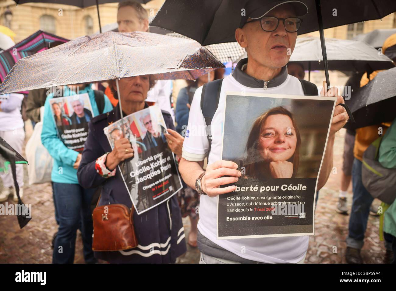 Peoples hold portraits of French detainees in Iran, Cecile Kohler and ...