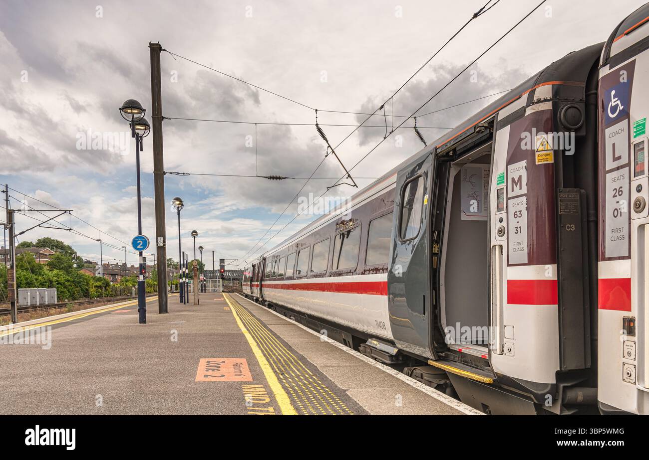 The side view of an old Intercity 225 train with an open door stands ...