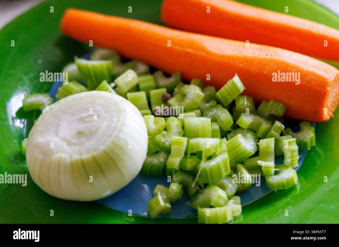 fresh, chopped vegetables on a green surface: a large carrot, chopped ...