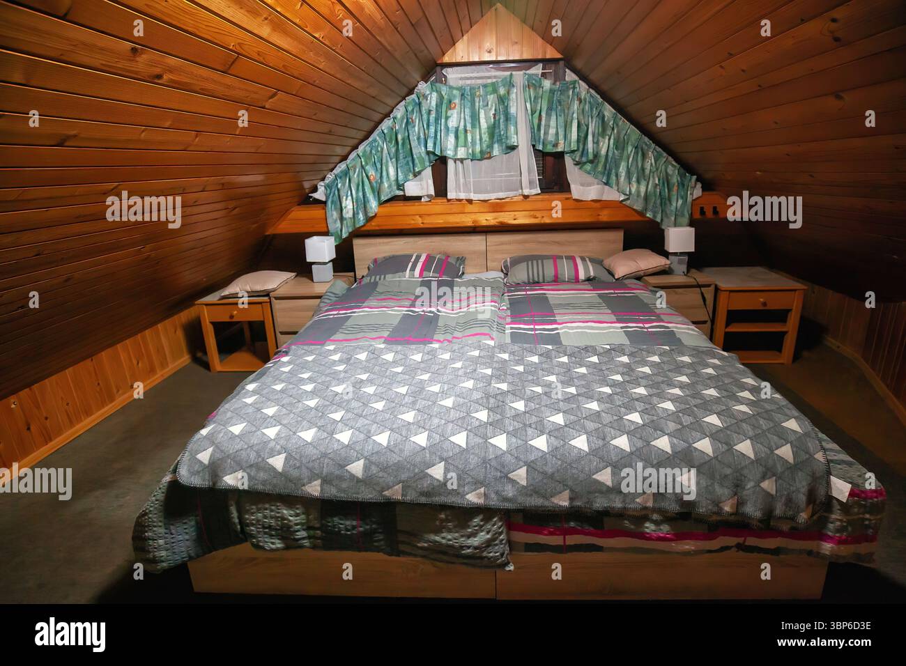 Wooden bed in attic in mountain hut. Bedroom with sleeping double bed ...