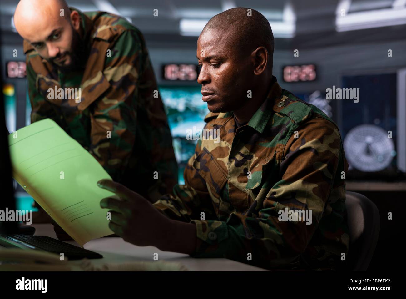Military officer reading intel documents to organize mission activities ...