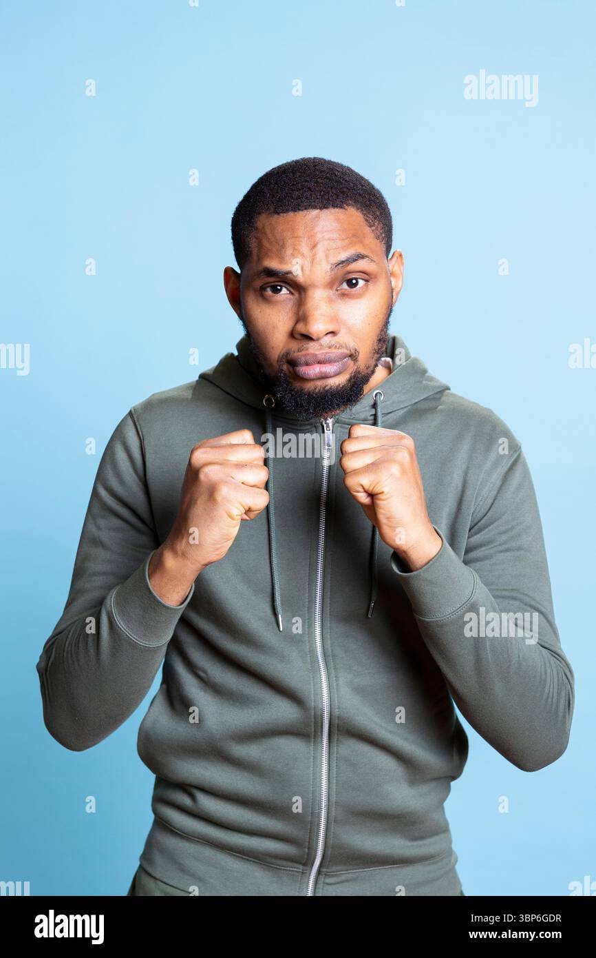 Active athletic african american guy clenching his fists on camera ...