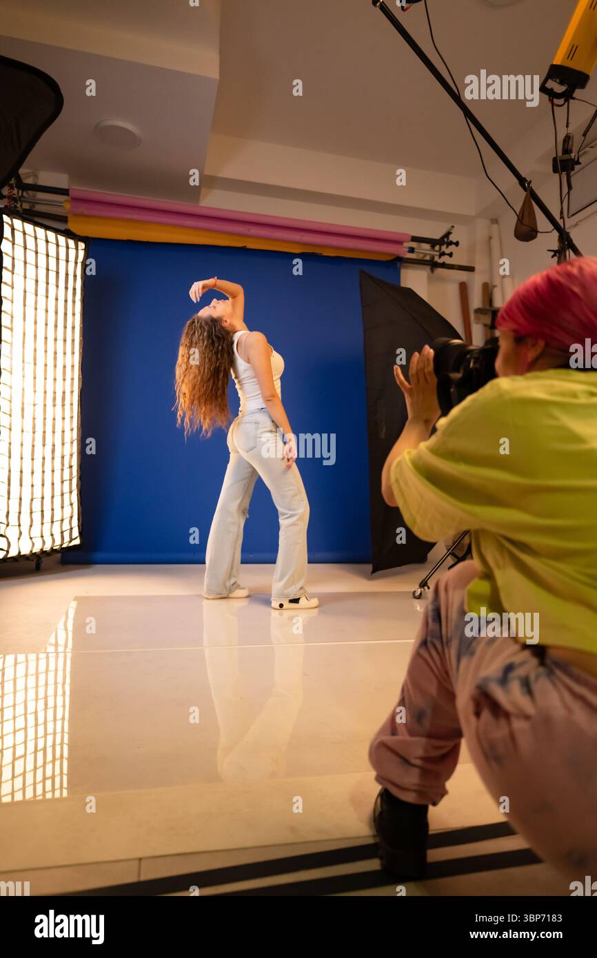 A model strikes a pose while a photographer captures the scene in a ...