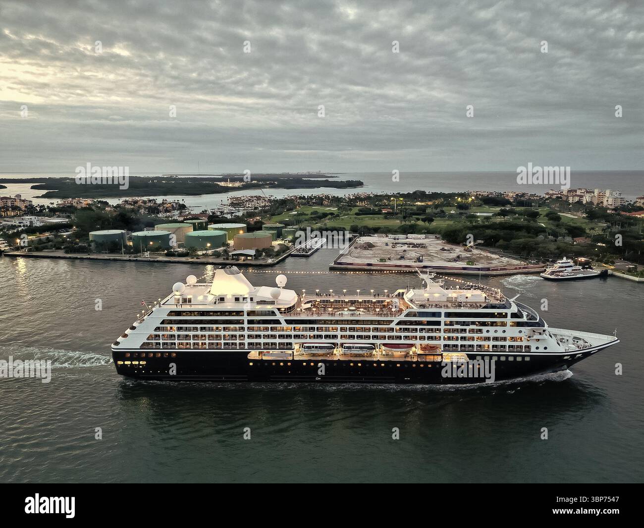 Cruise ship vacation and travel at night. Aerial view of luxury liner. Ship leaving Miami beach ...