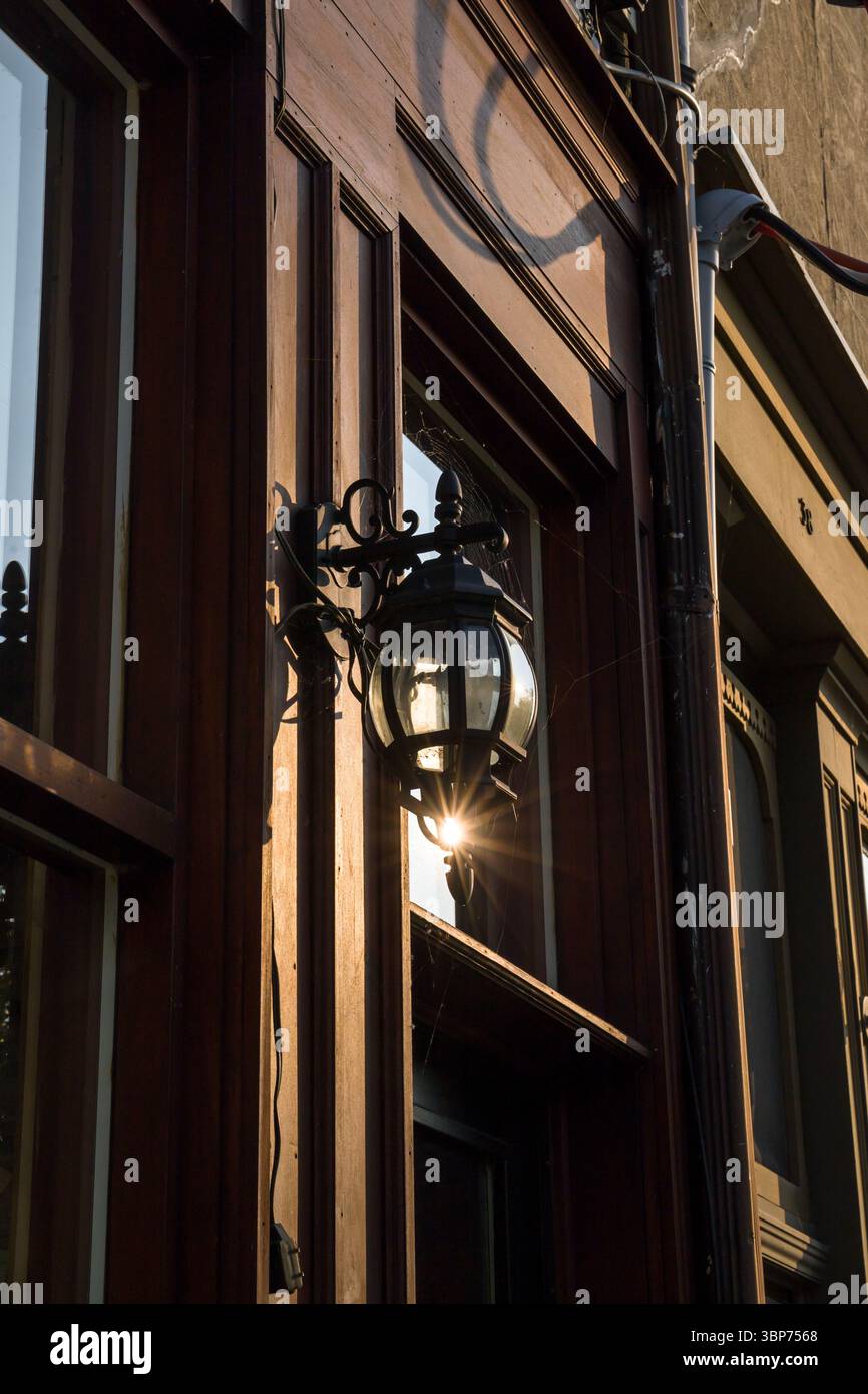 Vintage still life - old street lamp hanging on a window with sun rays ...
