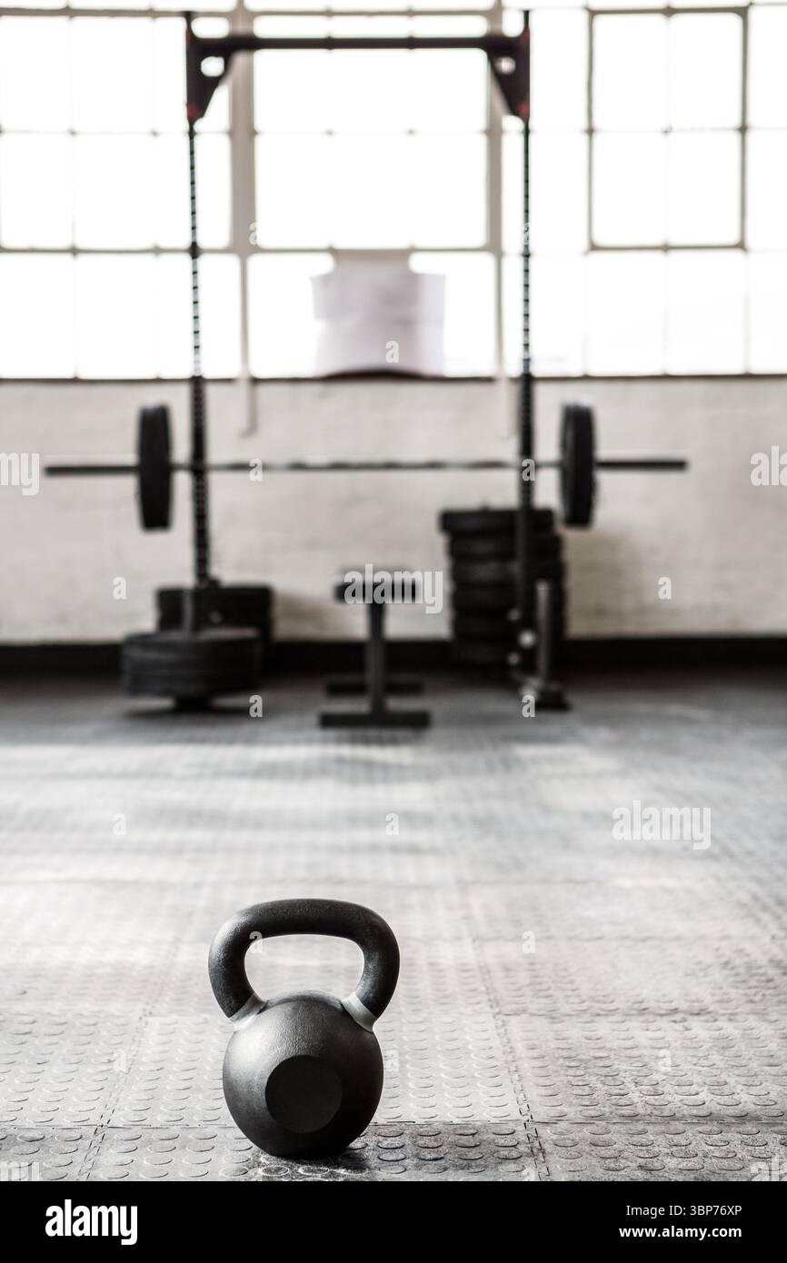 Black kettlebell is sitting on rubber floor in flat design gym with ...