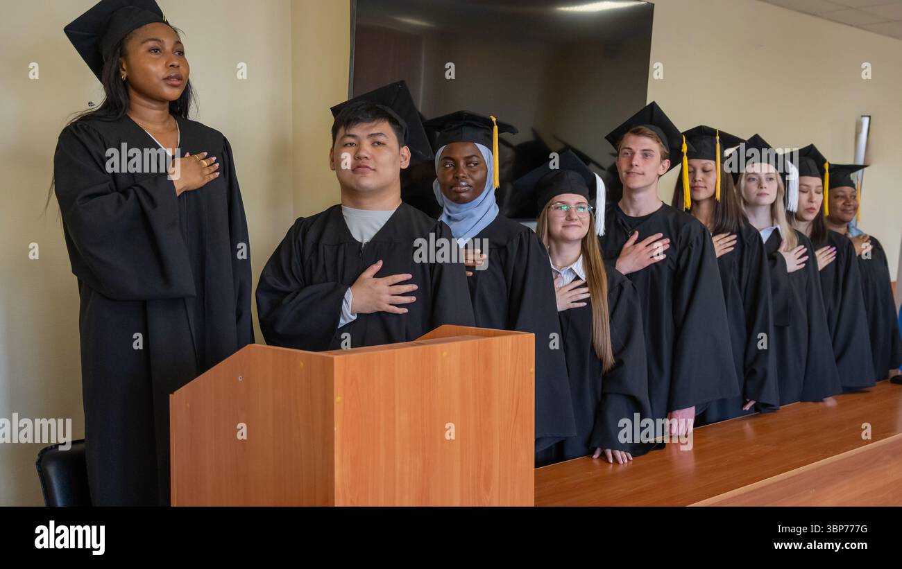 Graduates stand proudly ceremony hands hi-res stock photography and ...