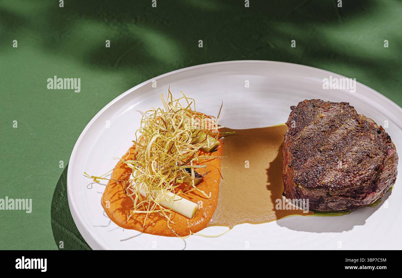 Food, A beautifully presented steak dish featuring a seasoned cut of ...
