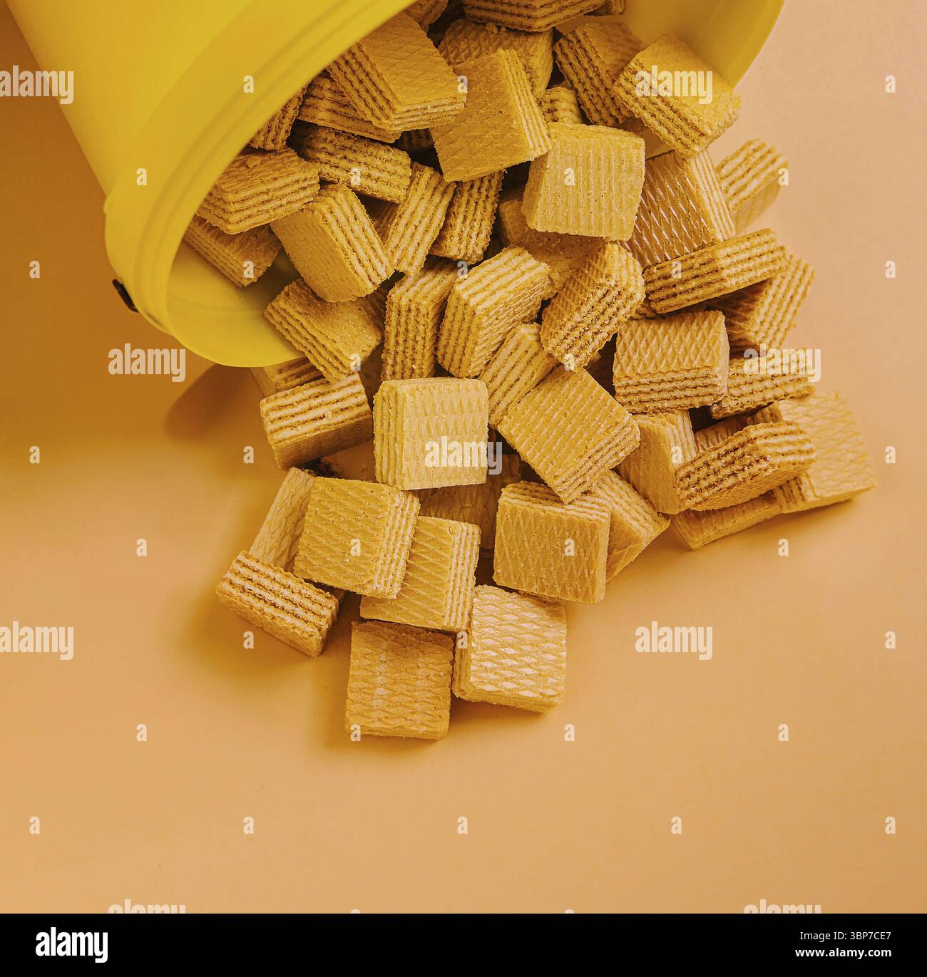 Food, A yellow bucket is overturned, scattering a pile of crispy wafers ...