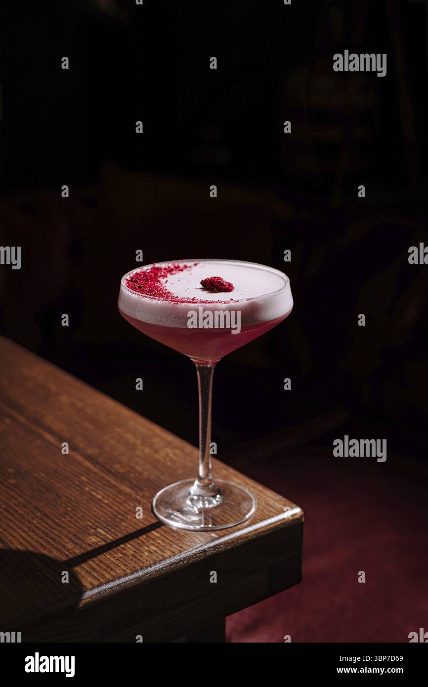 Food, A beautifully crafted raspberry cocktail sits on a wooden surface ...