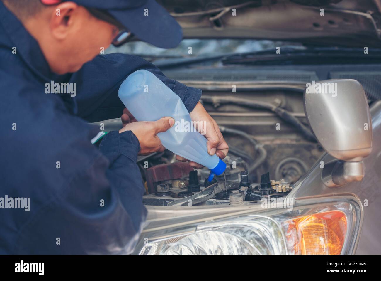 Car Mechanic man hands pouring Deionized purified Distilled water for ...