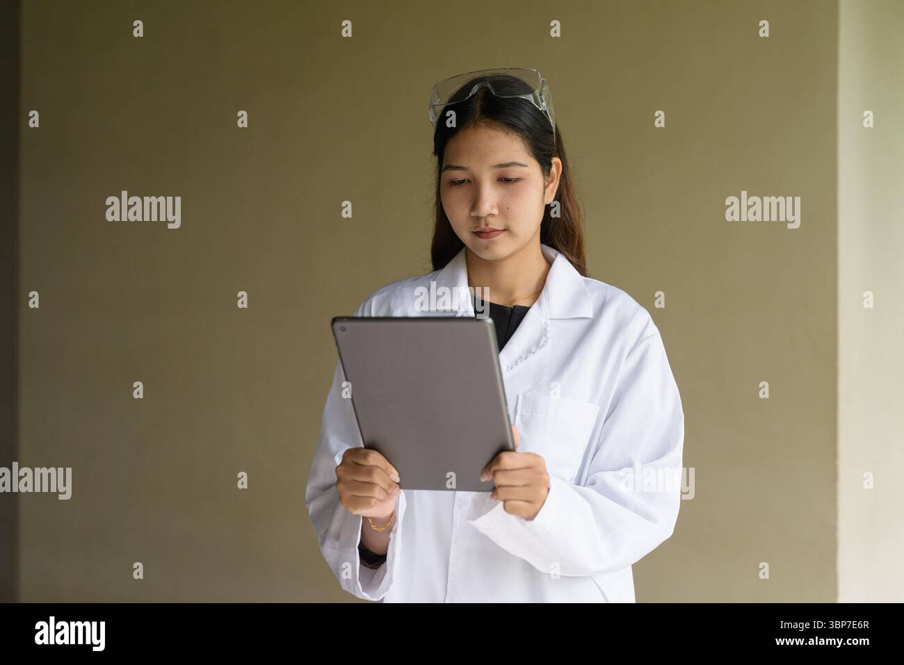 Young Asian scientist woman wearing lab coat and goggles Stock Photo ...
