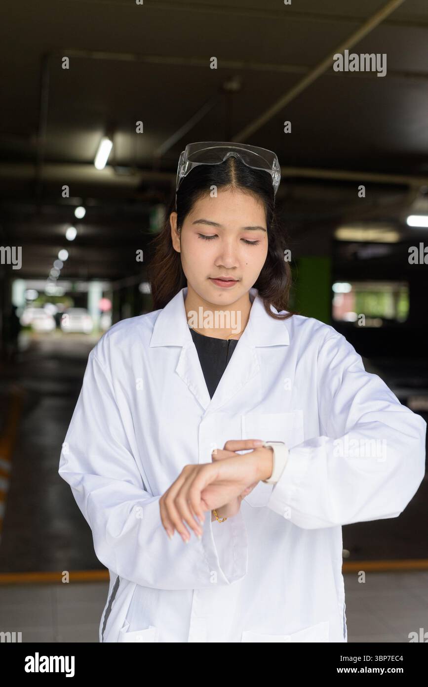 Young Asian scientist woman wearing lab coat and goggles outside of ...