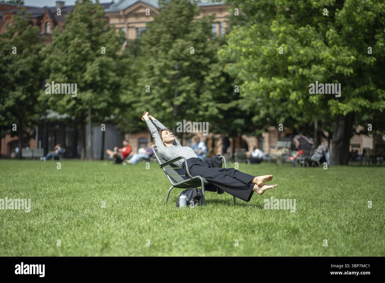 Lazy woman resting on grass outside, sleeping outdoors, dozing bathing ...