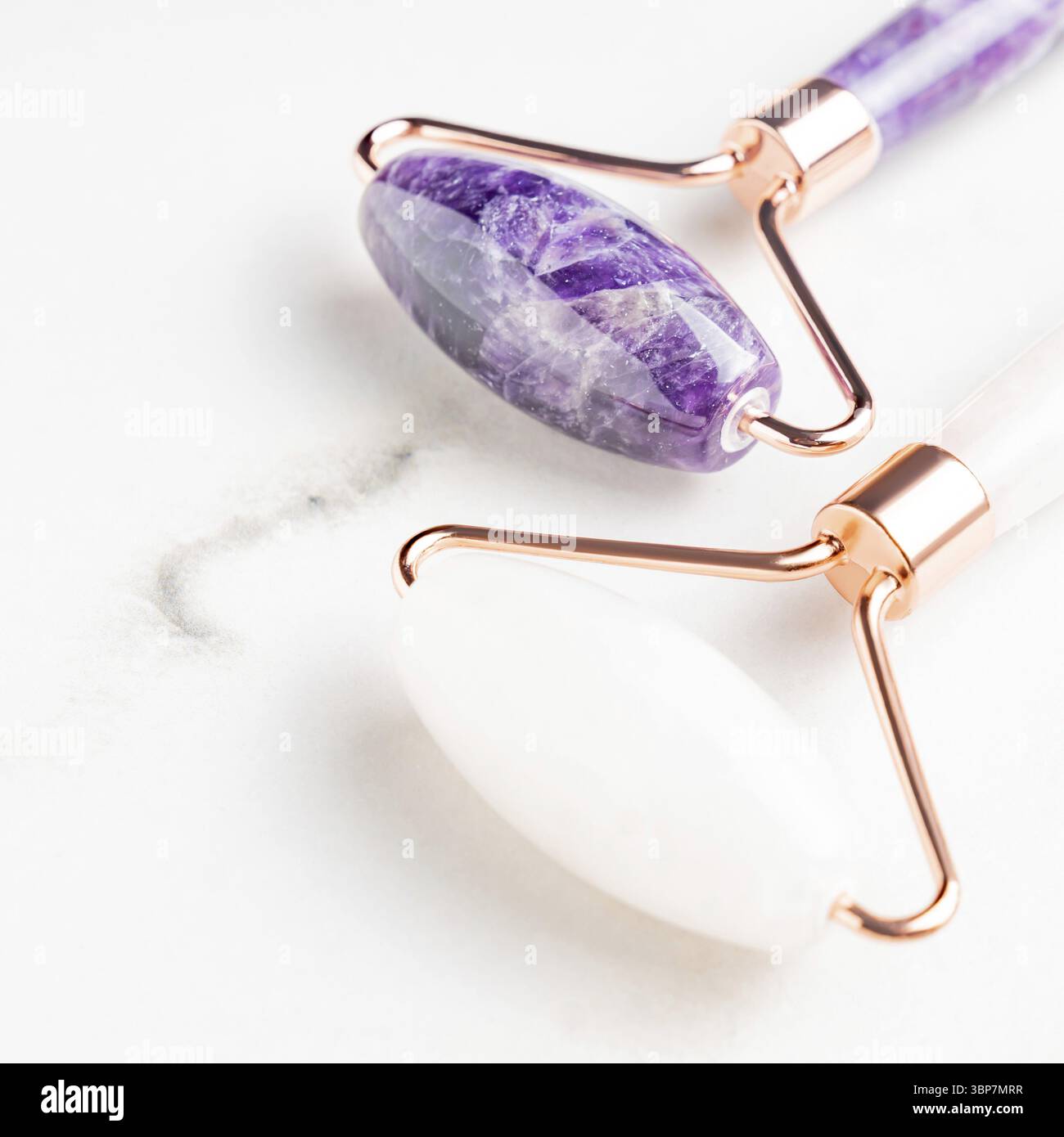 Set of Facial massage amethyst gua sha rollers on white marble ...