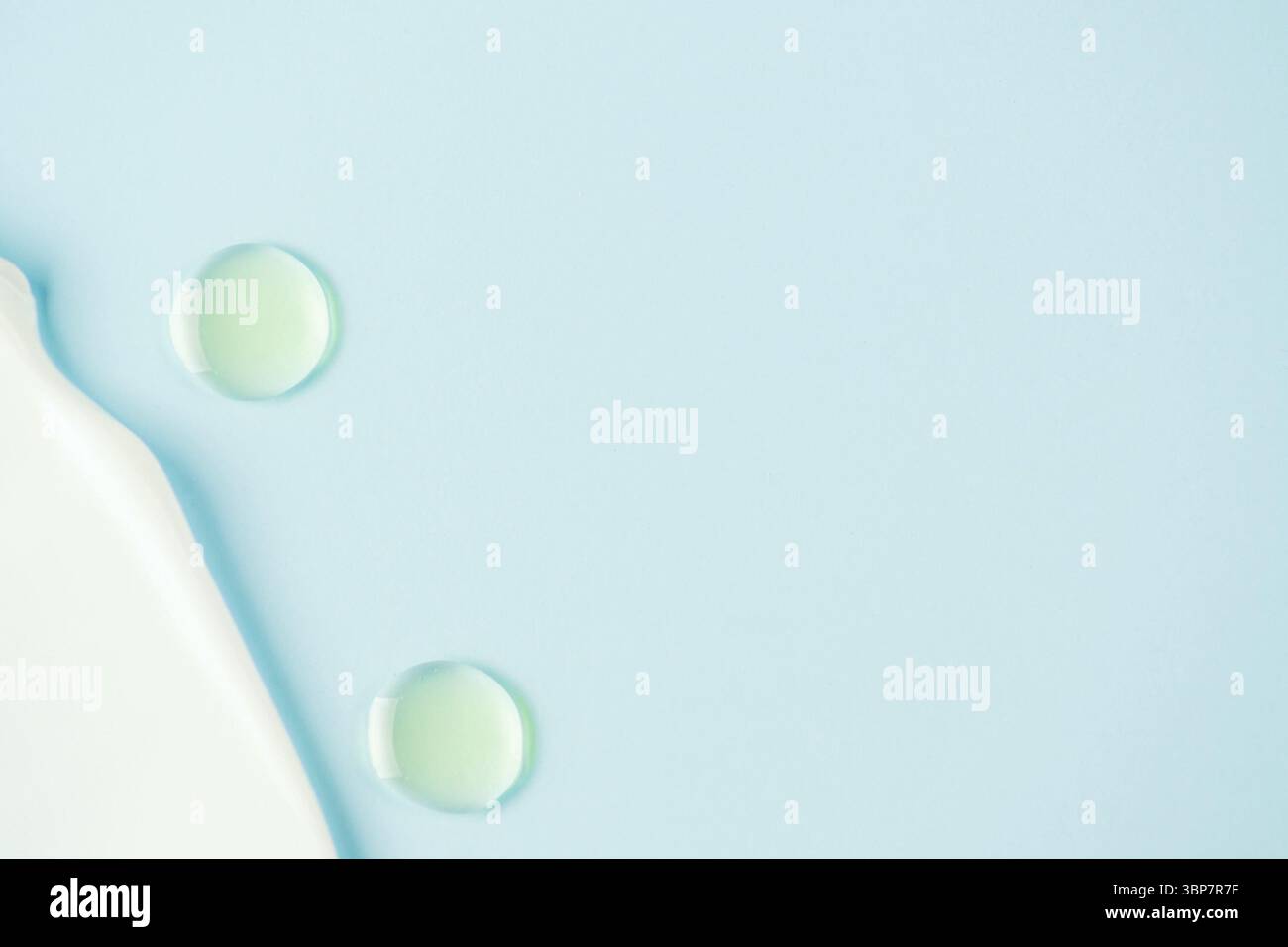 Face or body cream and drops of beauty oil on blue background with copy ...