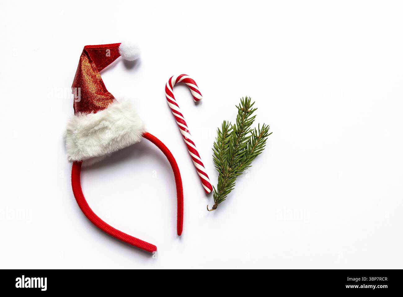 Hair band with santa hat, candy cane and fir tree branch on white ...
