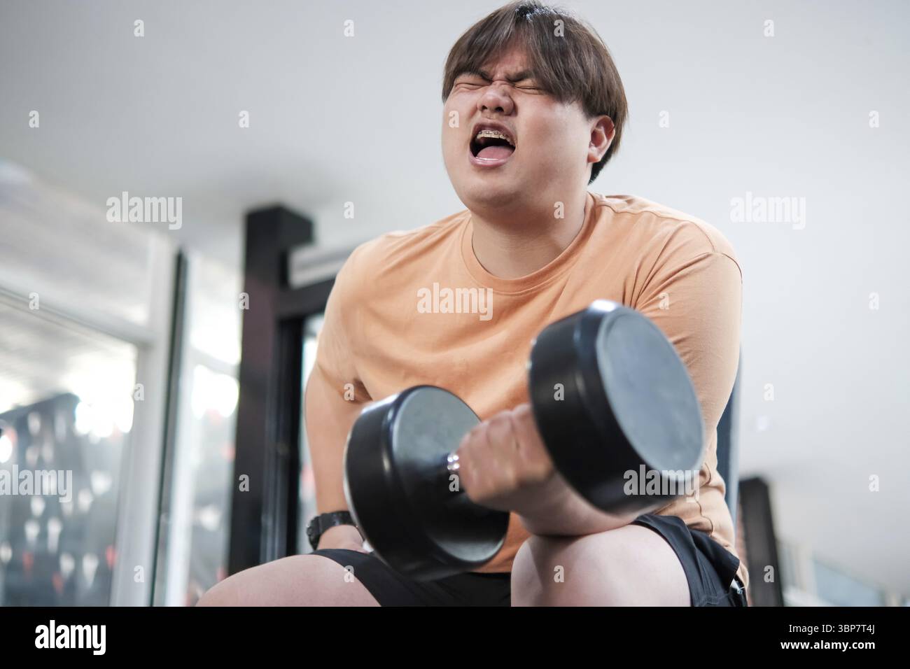 A man is lifting weights and is in a very angry mood. He is wearing an ...
