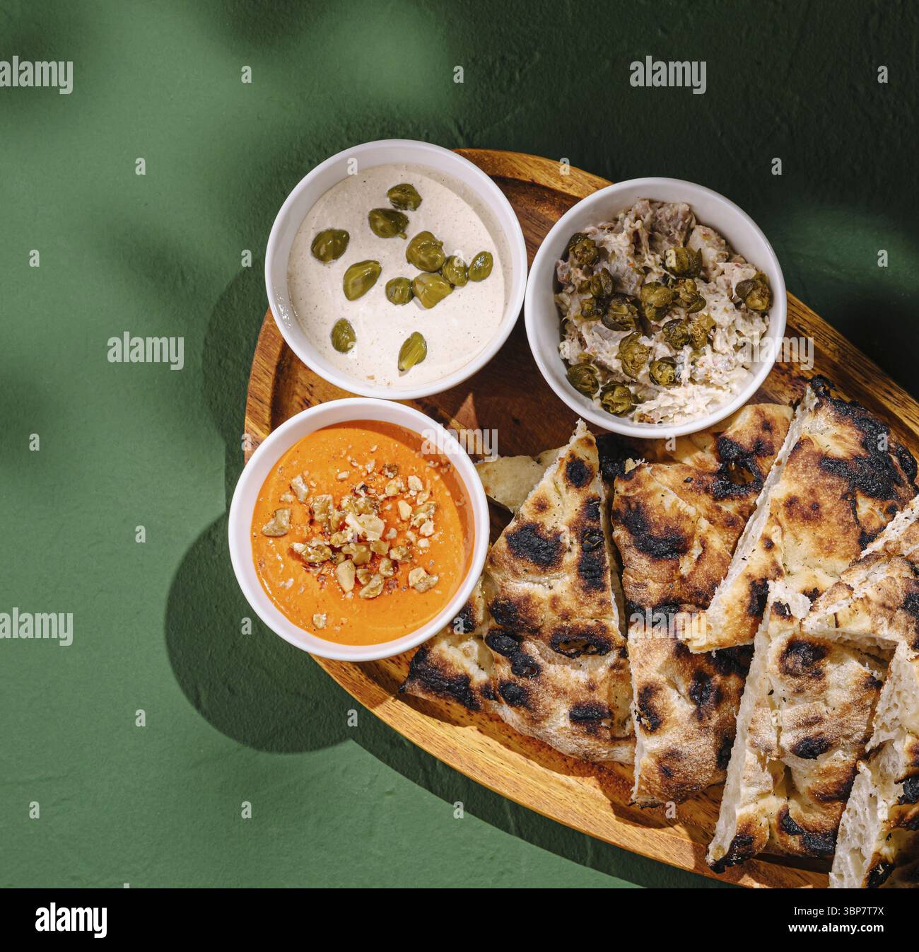Food, A wooden platter features freshly baked bread accompanied by ...