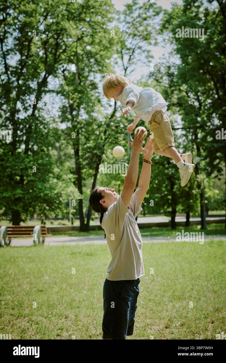 Happy Father Lifting Child Boy While Playing Outdoors Stock Photo - Alamy