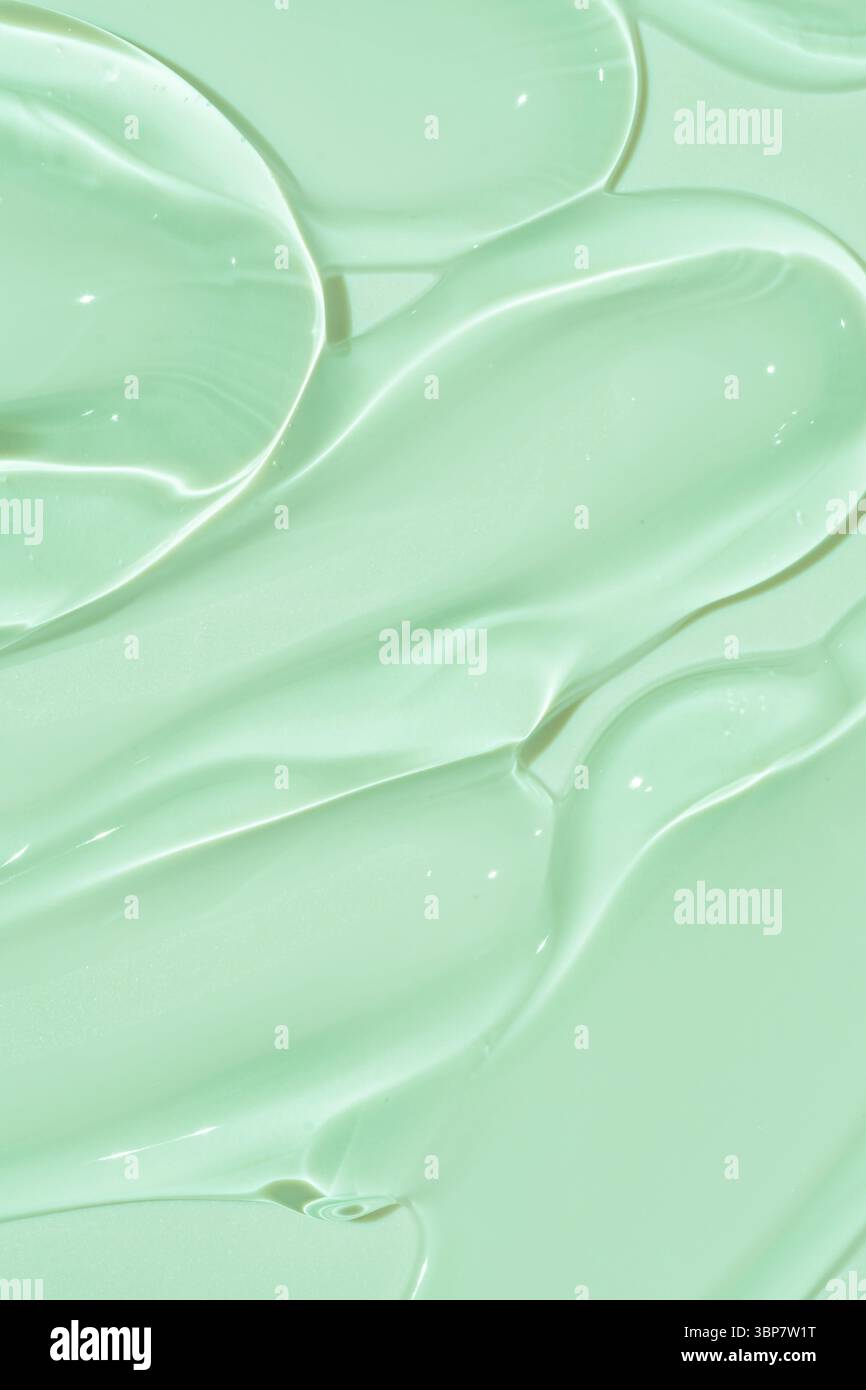 Cosmetic smears cream texture on green background. Beauty serum drop ...