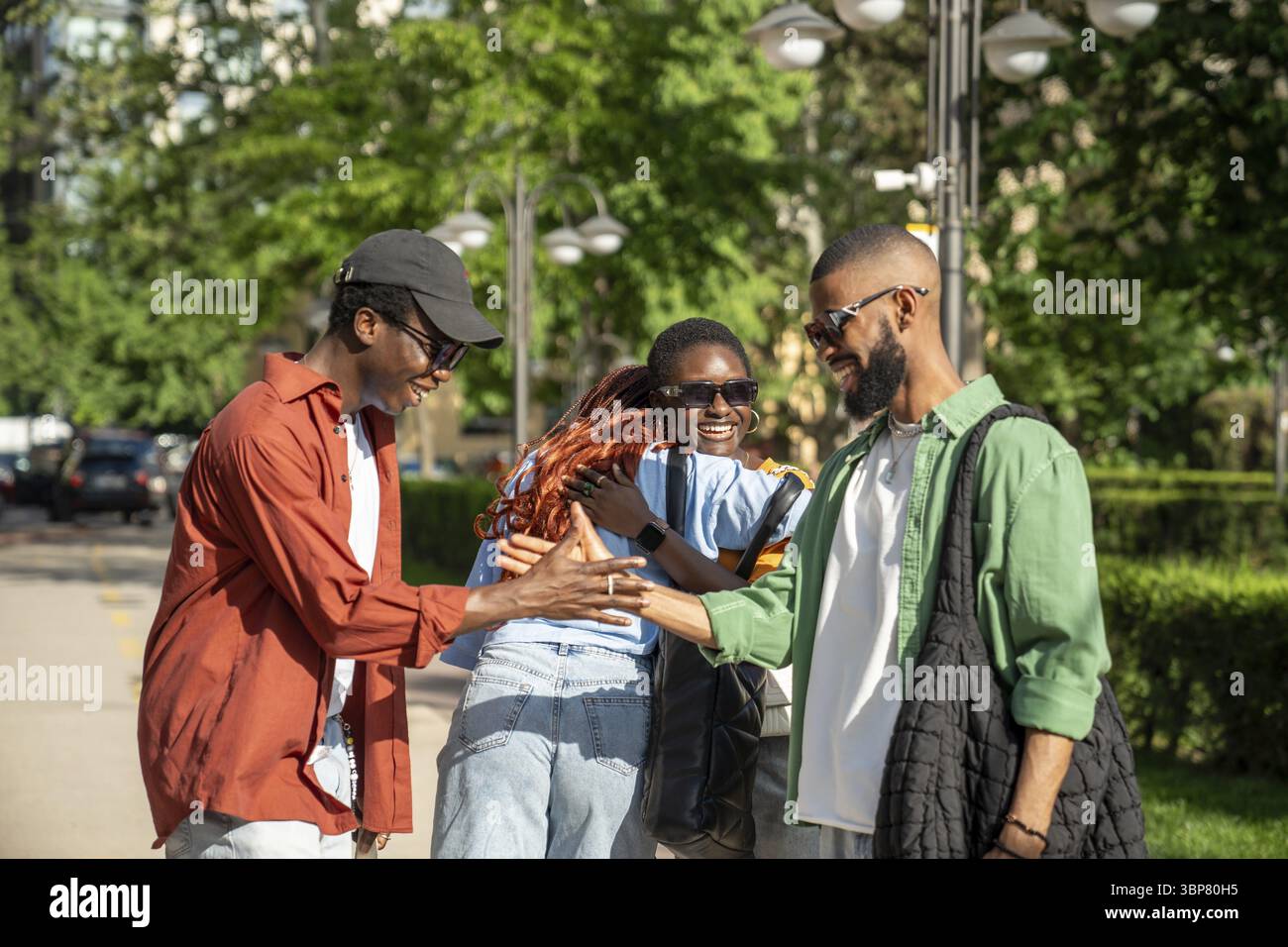 Joyous hello of african american friends on street. Happy group of ...