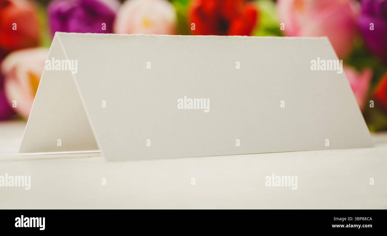 Showing blank white folded tent card resting on light tabletop ...