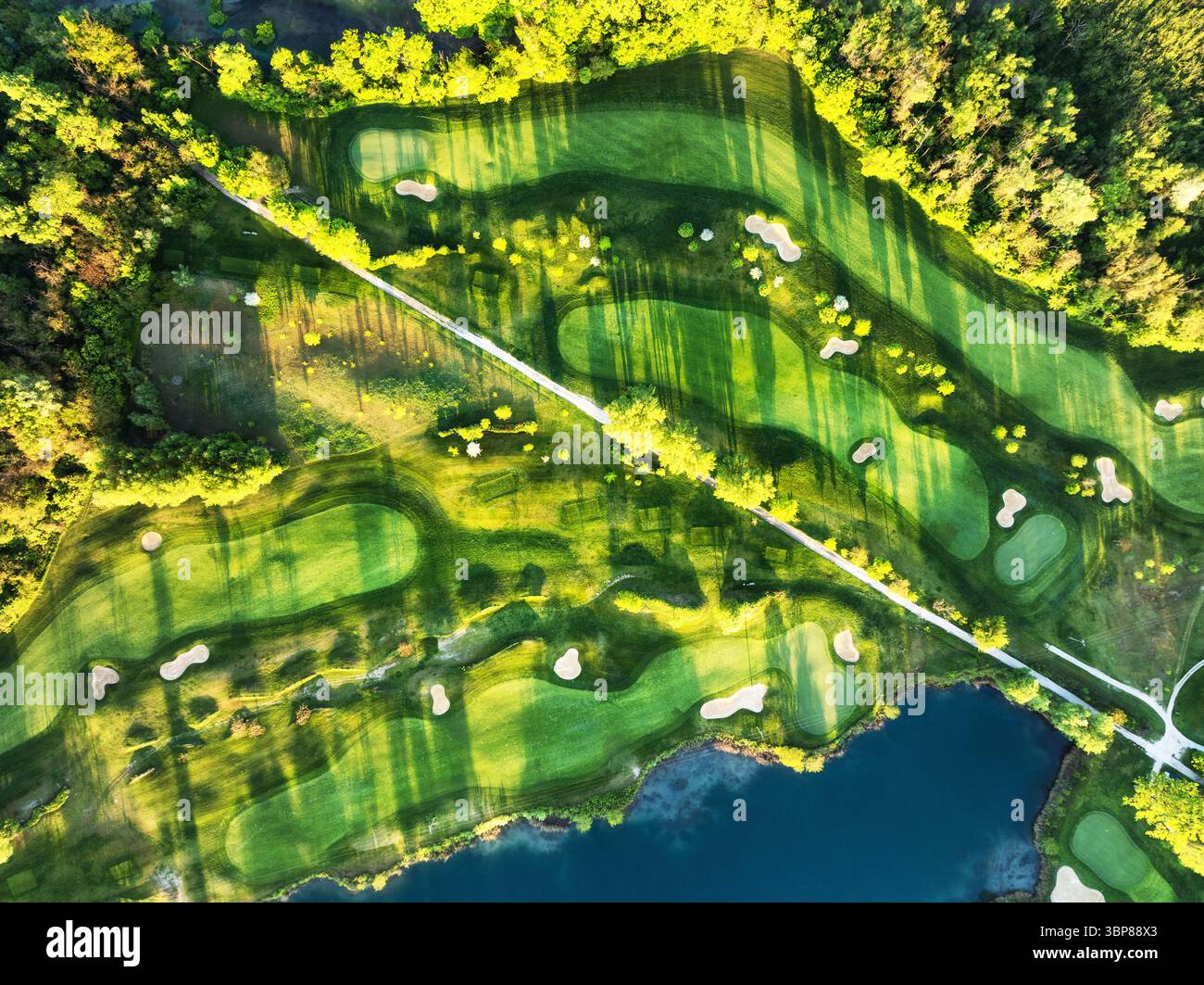 Aerial view of sunset over golf course with spring colored trees and ...