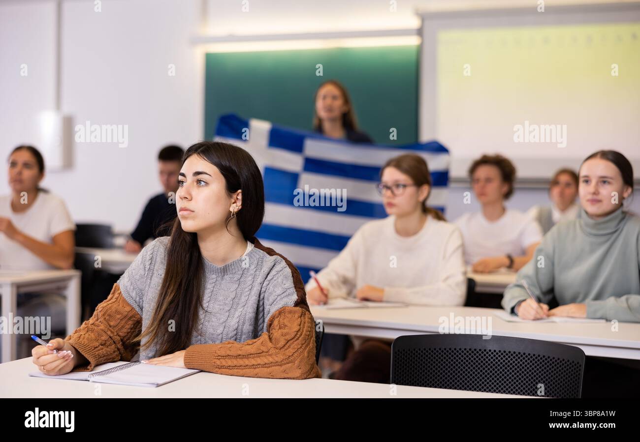 Teacher stands behind students with flag of Greece Stock Photo - Alamy