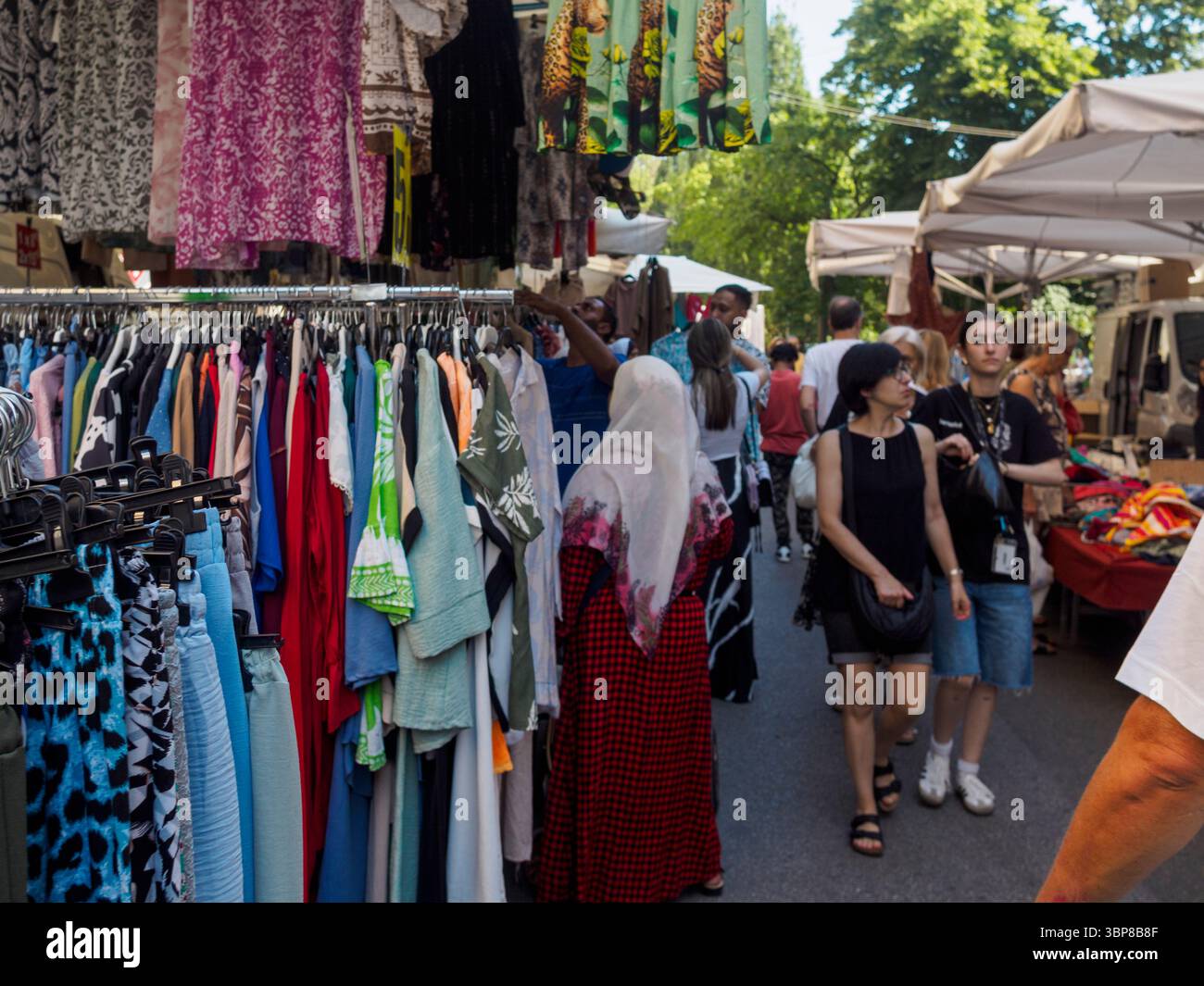 Cremona, Italy June 28th 2025 People walking and browsing colorful ...