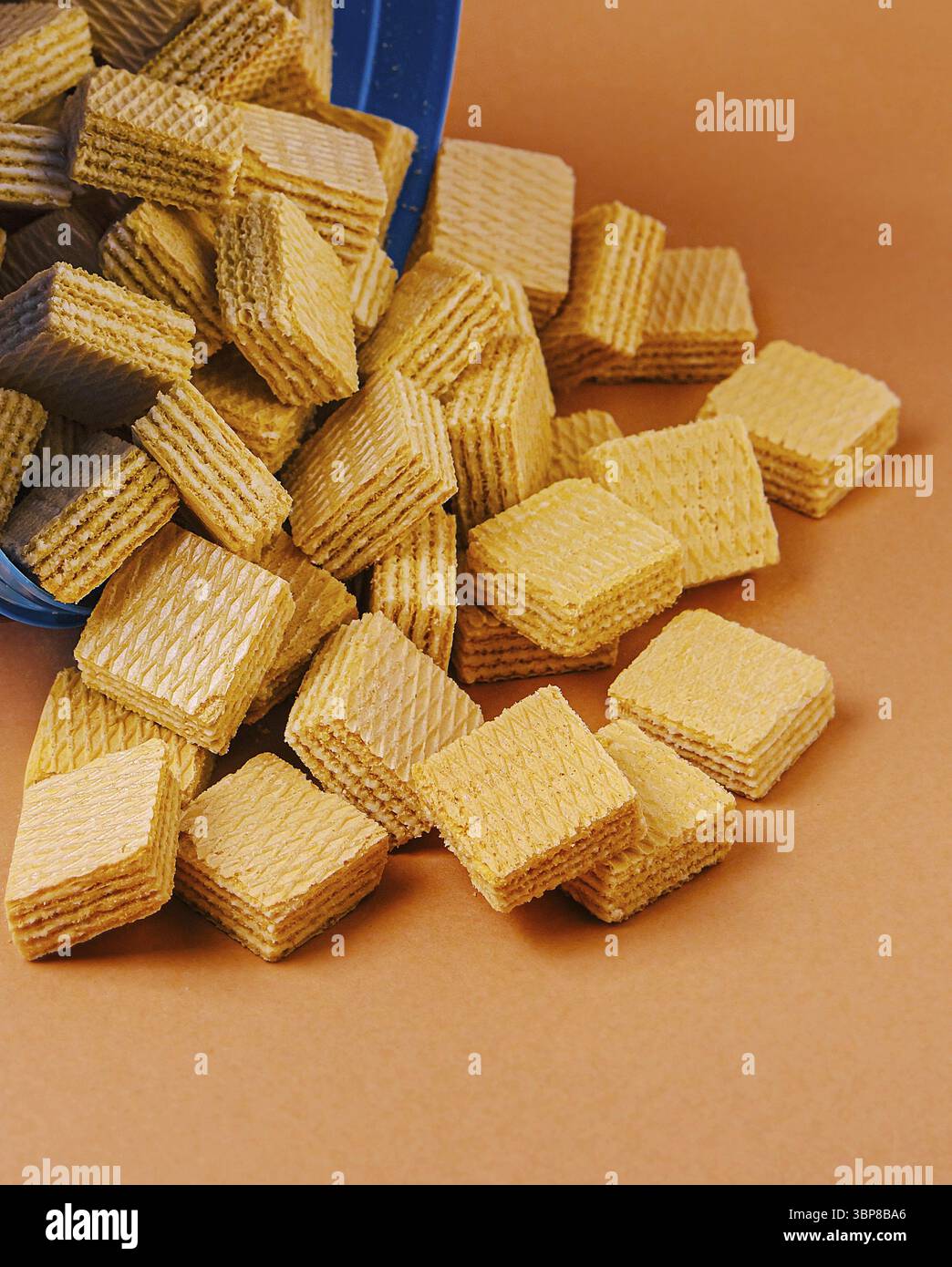 Food, A blue container spills an array of yellow wafers onto an orange ...