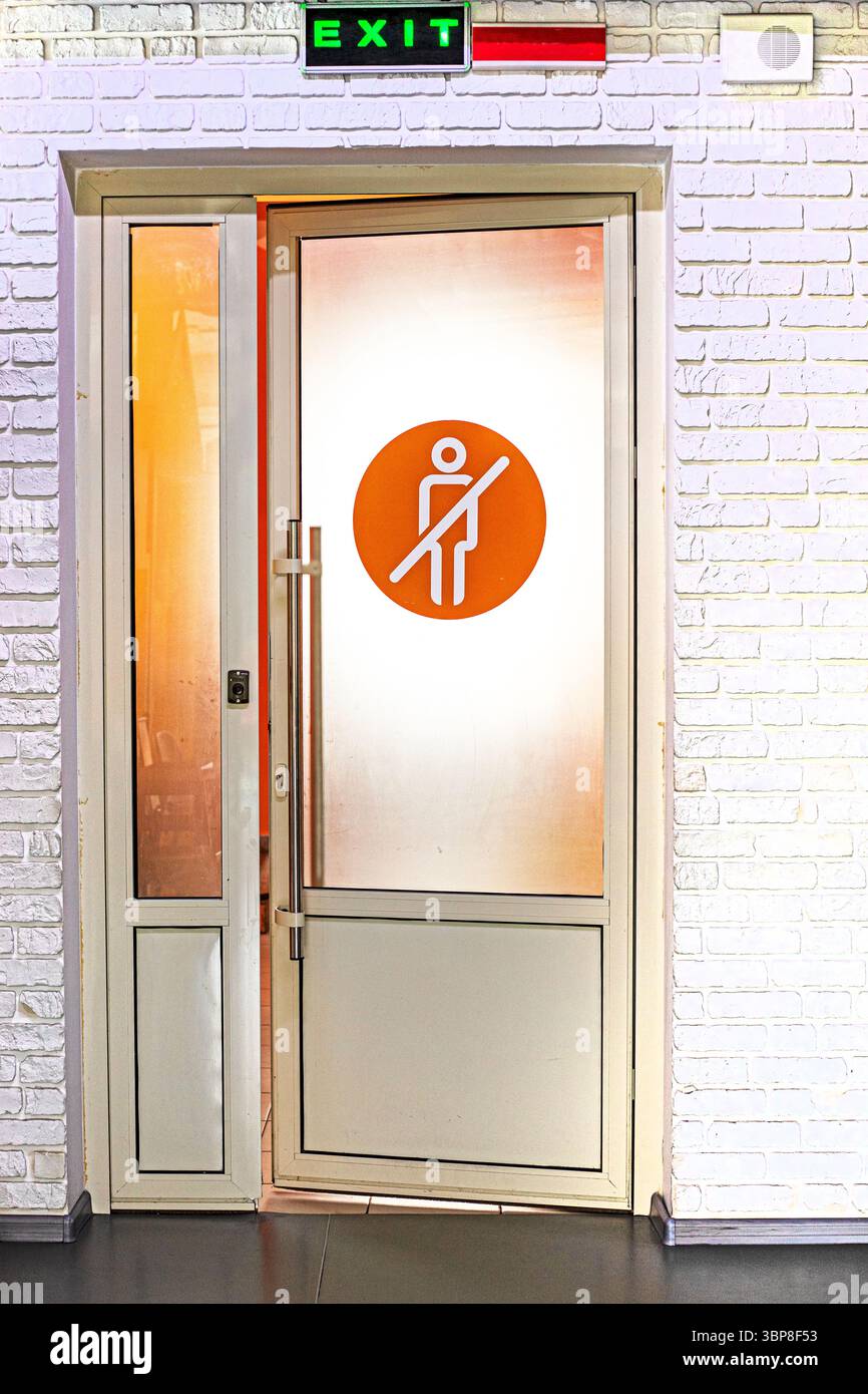 round orange schematic sign of a person prohibiting entry into these ...
