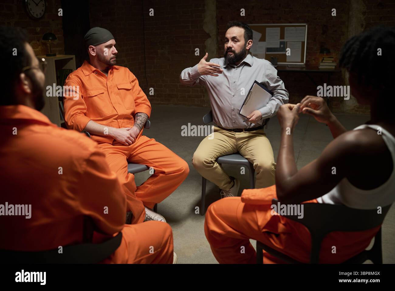 Diverse group of young adult prisoners sitting in circle participating ...
