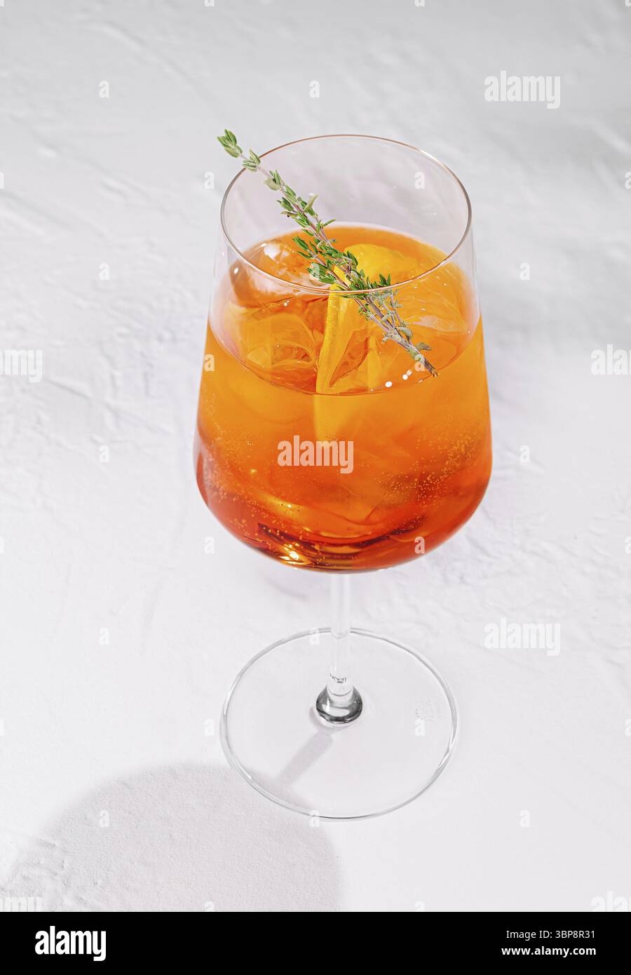 Food, Aperol spritz cocktail is standing on a white table, garnished ...