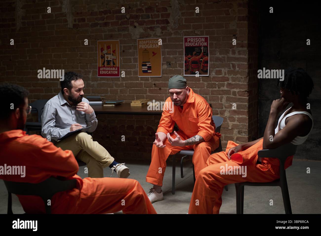 Group of men sitting with counselor discussing rehabilitation in prison ...