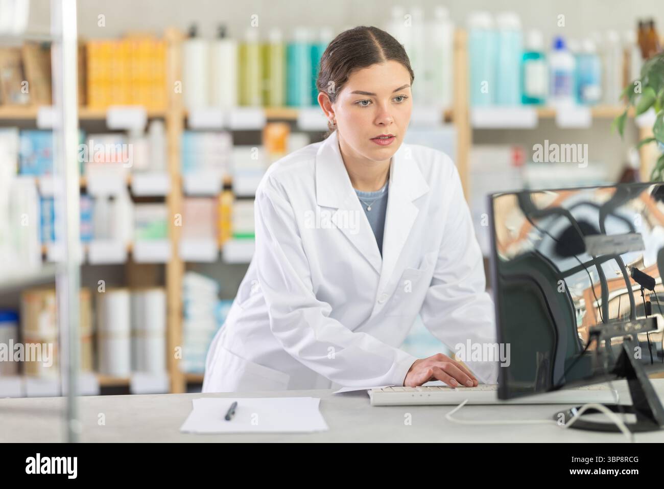 Pharmacist processing supply orders through pharmacy system Stock Photo ...