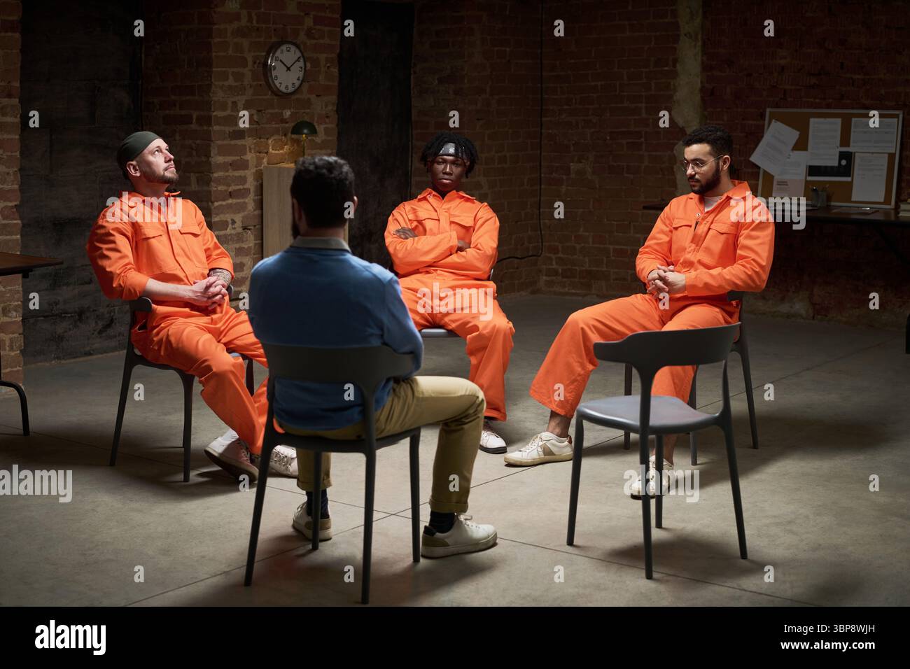 Group of young adult male convicts sitting in circle wearing prison ...