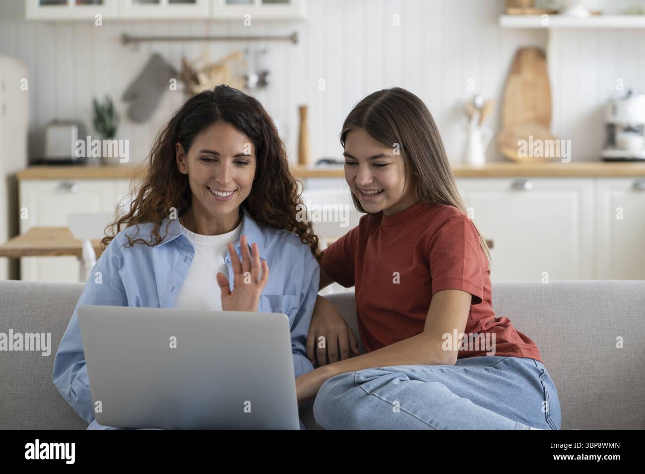 Happy family mother and teen girl daughter waving hand saying hello to ...