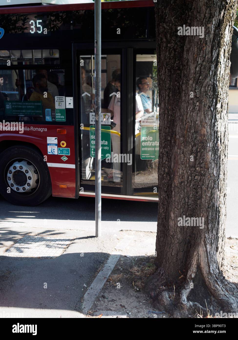 Bologna, Italy July 3rd 2025 Urban passengers entering red city bus 35 ...