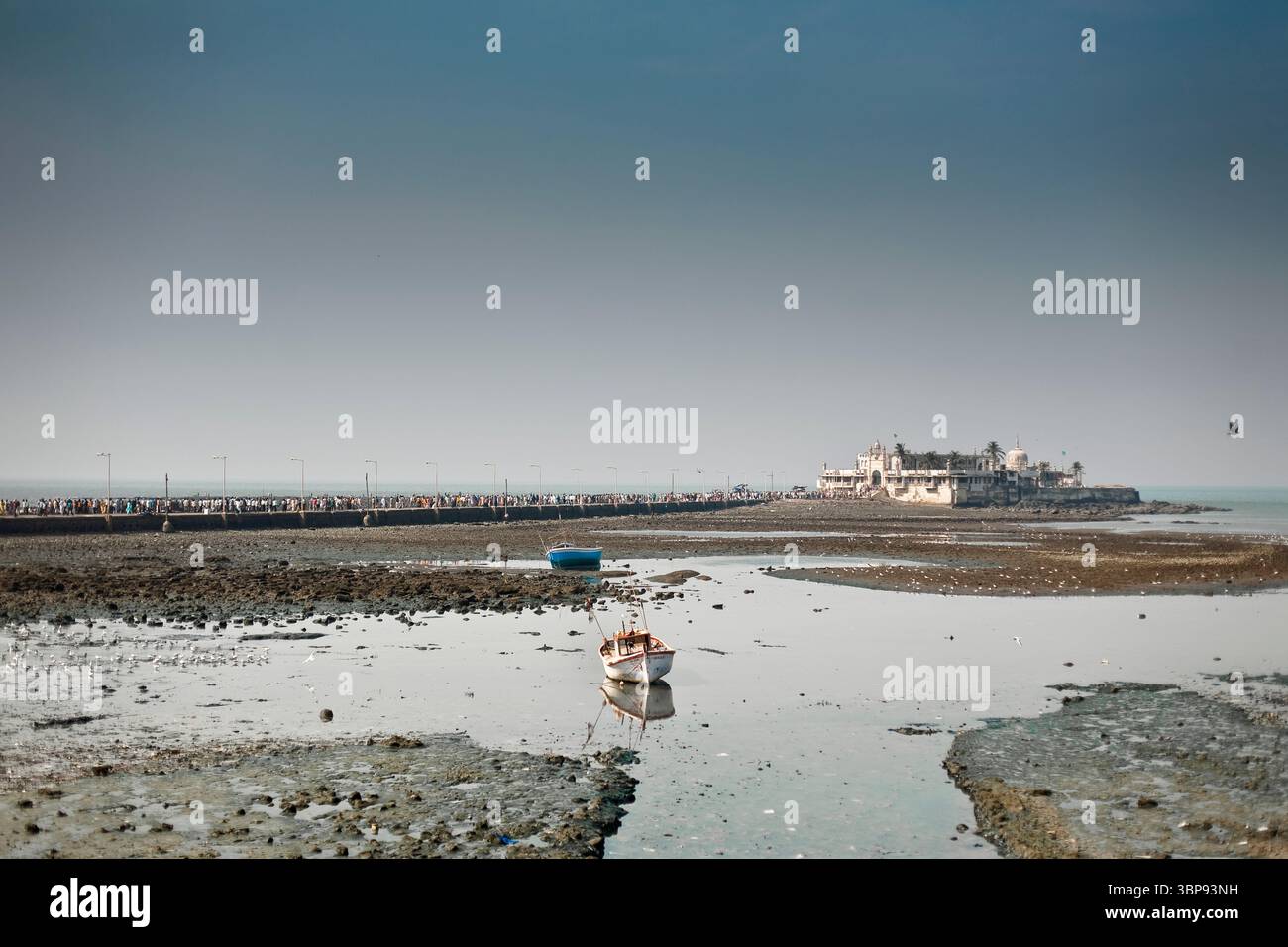 Pilgrims cross a narrow path during low tide to visit a secluded Mosque ...