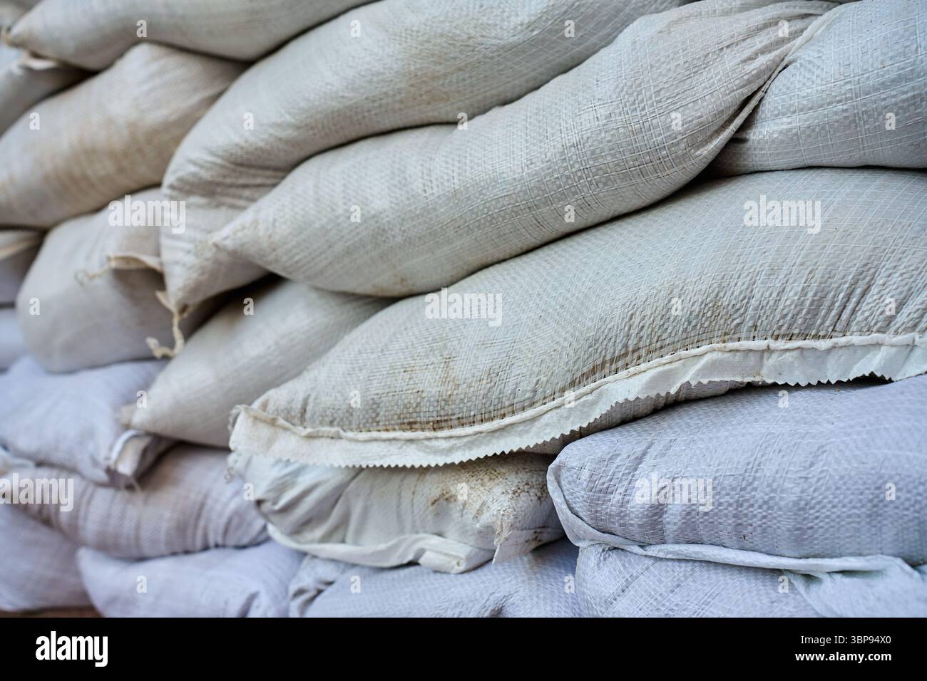 Rows of sandbags stacked as flood barrier on city street. Emergency ...