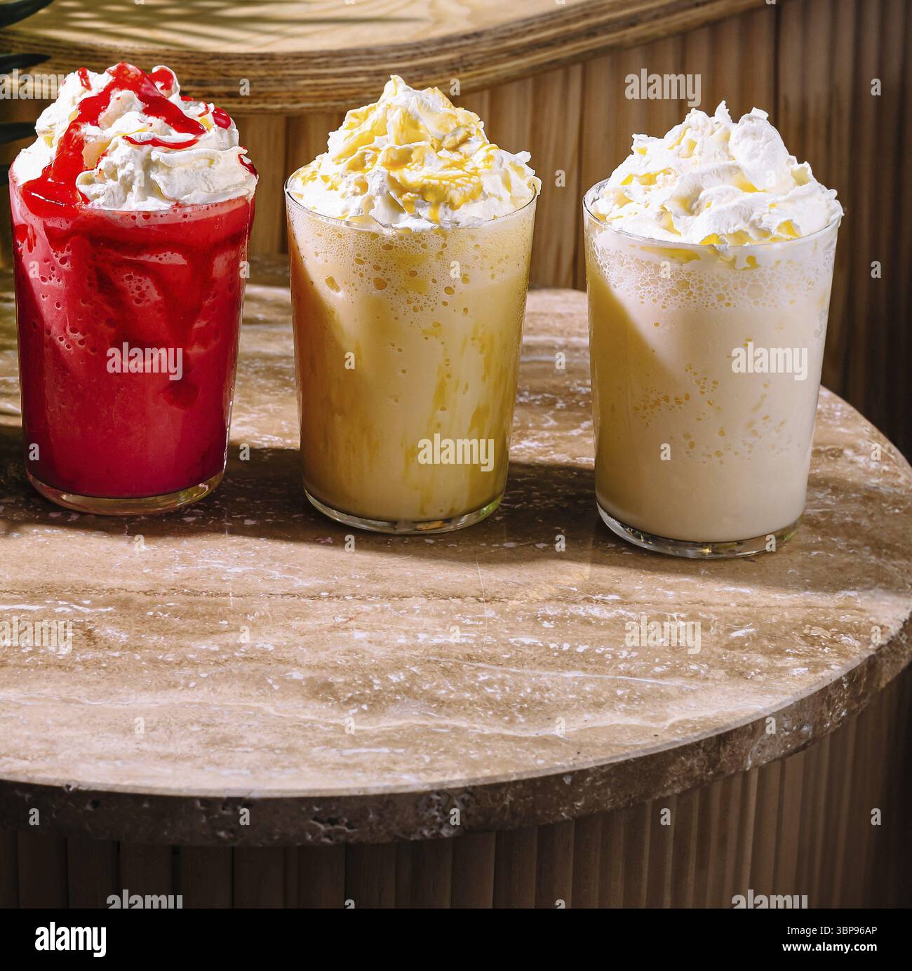 Food, Three milkshakes with whipped cream and different toppings are ...