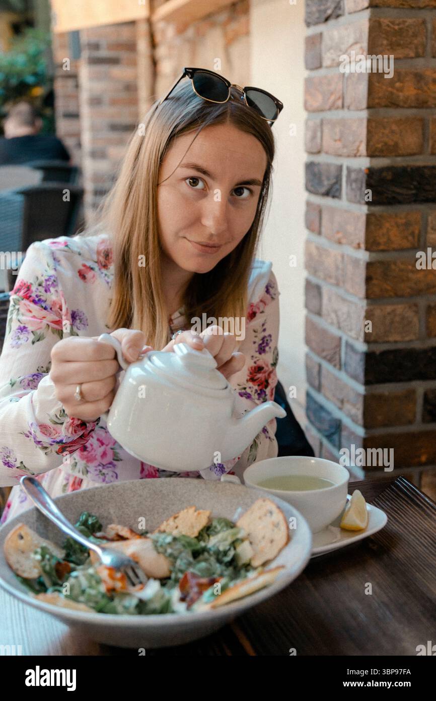 Woman smiling and pouring tea during brunch Stock Photo - Alamy