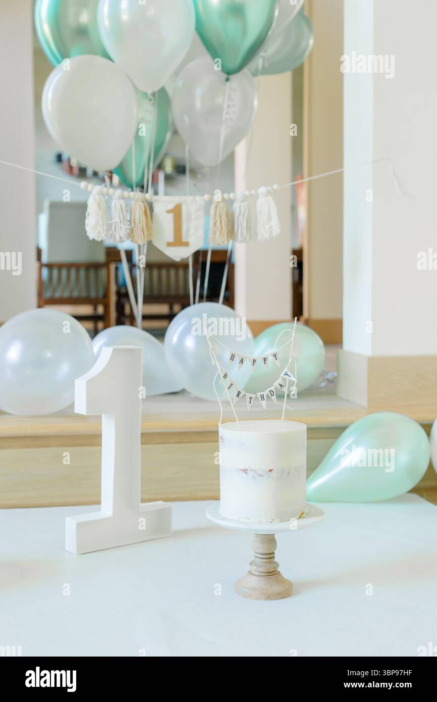 First birthday setup with cake, balloons, and number one decor Stock ...