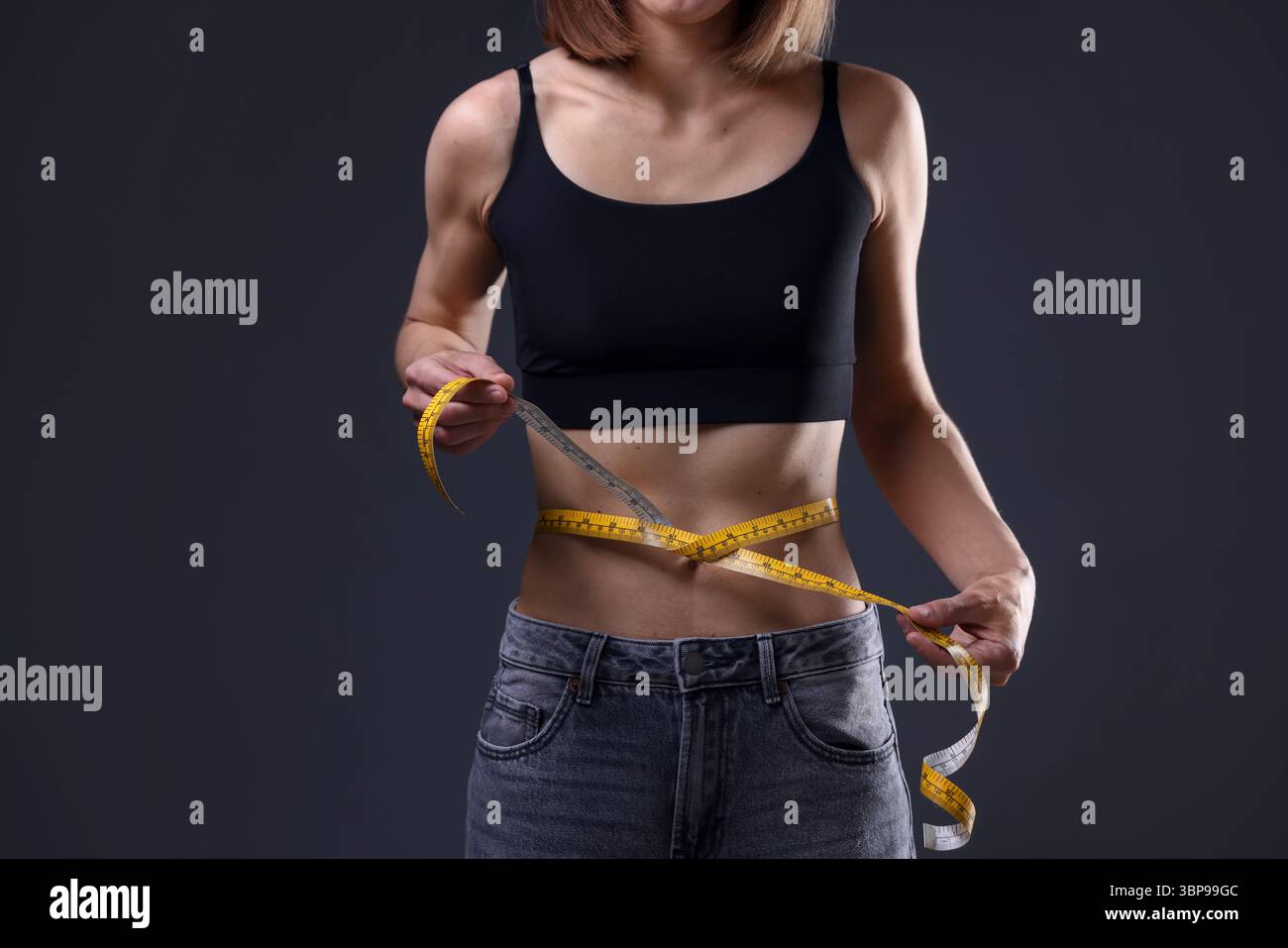 Anorexic woman measuring her waist on grey background, closeup Stock ...